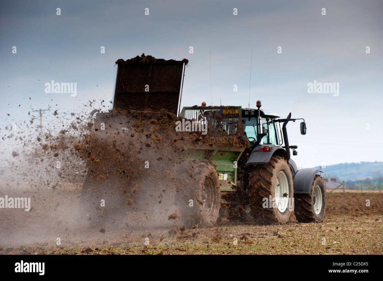 Muck spreading with a Valtra T151 tractor, on a field to be planted ...