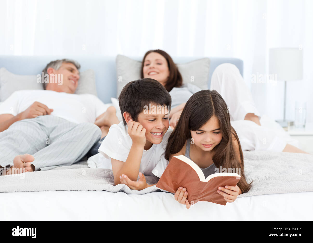 Parents talking while their children are reading Stock Photo - Alamy