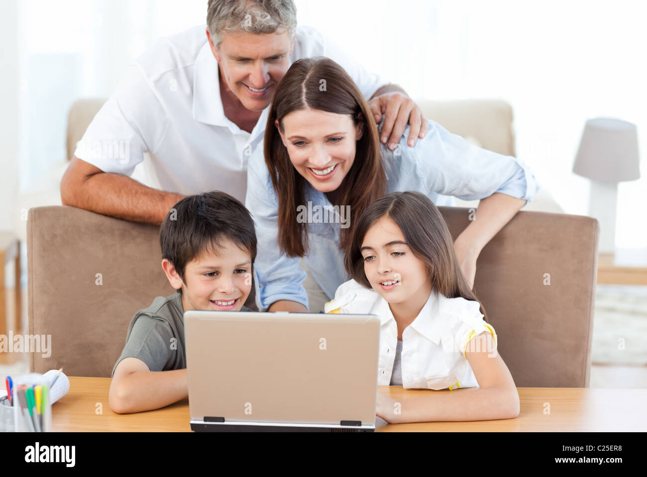 Family looking at the laptop Stock Photo - Alamy