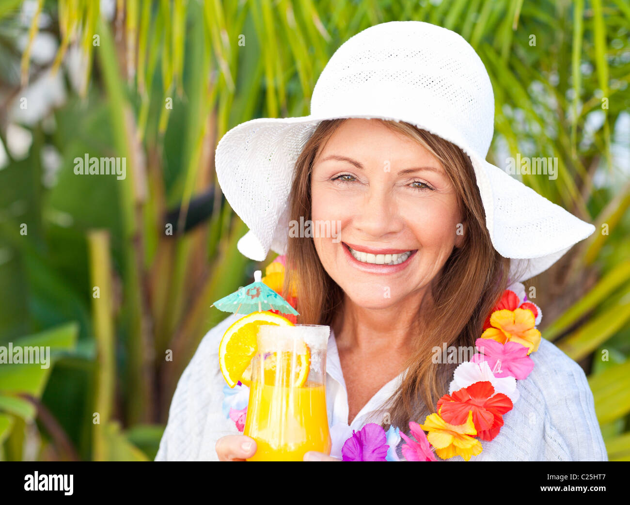 Retired woman drinking a cocktail under the sun Stock Photo - Alamy