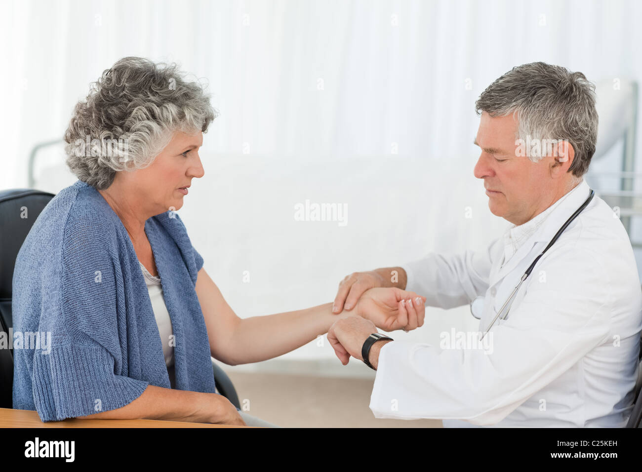 A senior doctor doing a check-up to his patient Stock Photo - Alamy