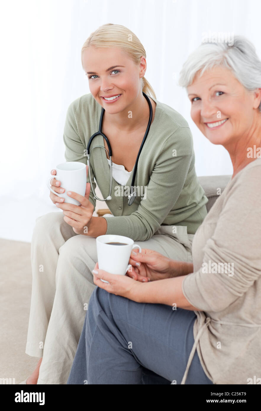 Doctor drinking with her patient Stock Photo - Alamy