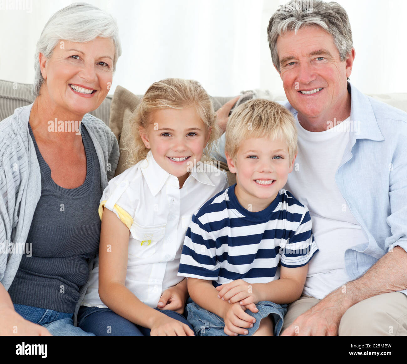 Happy family looking at the camera Stock Photo - Alamy