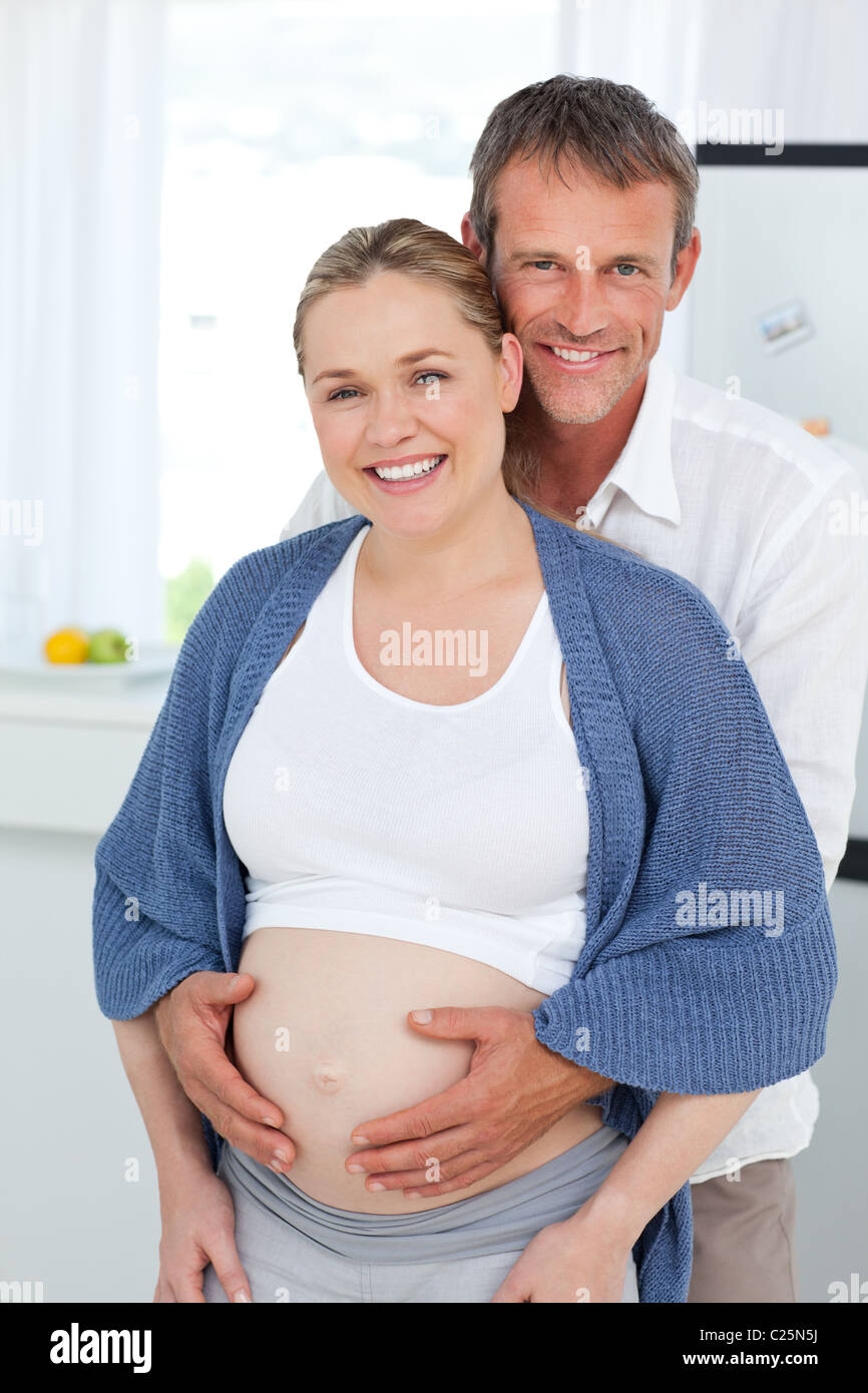 Young couple looking at the camera while they are hugging Stock Photo ...