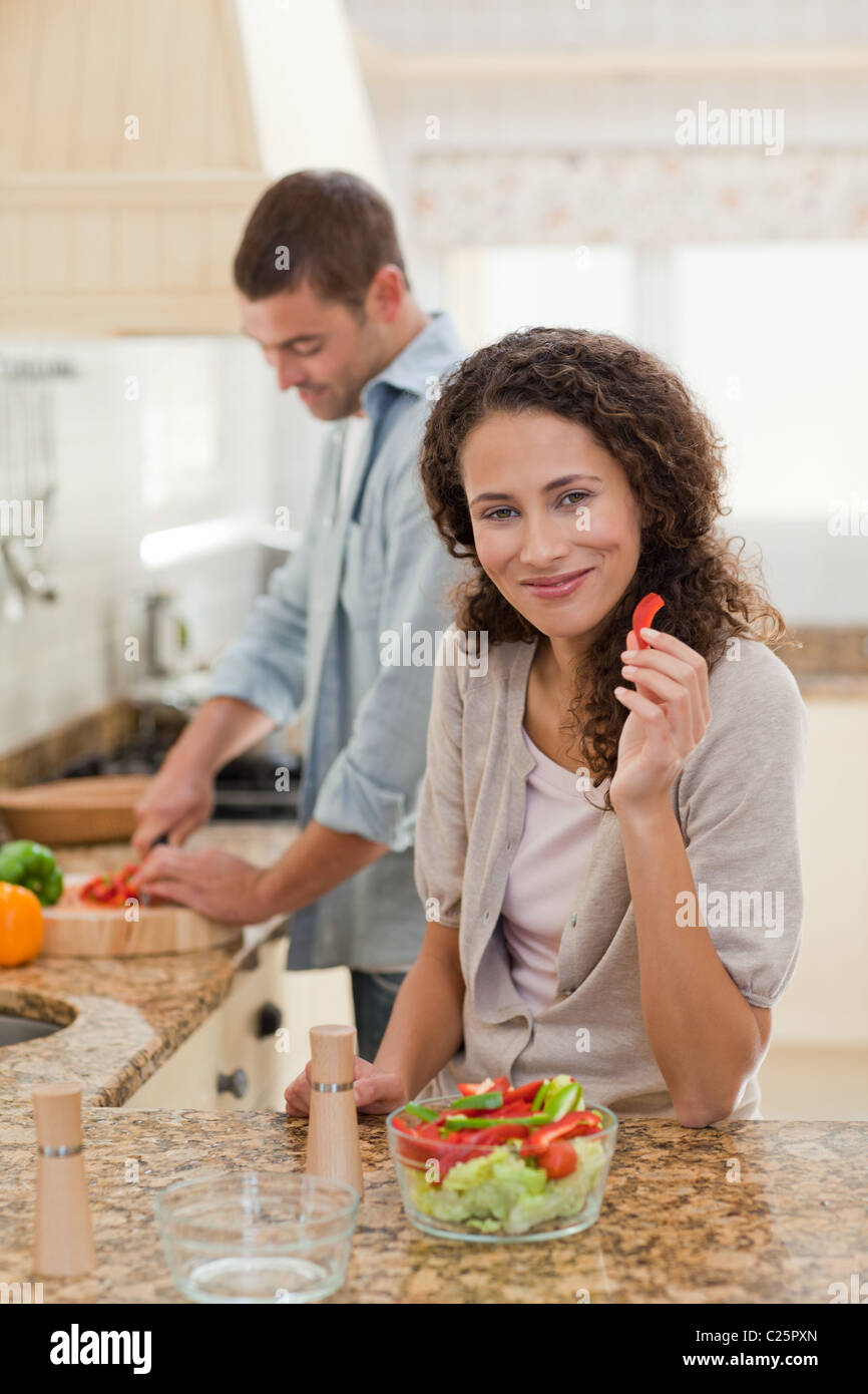 Woman eating while her husband is cooking Stock Photo - Alamy