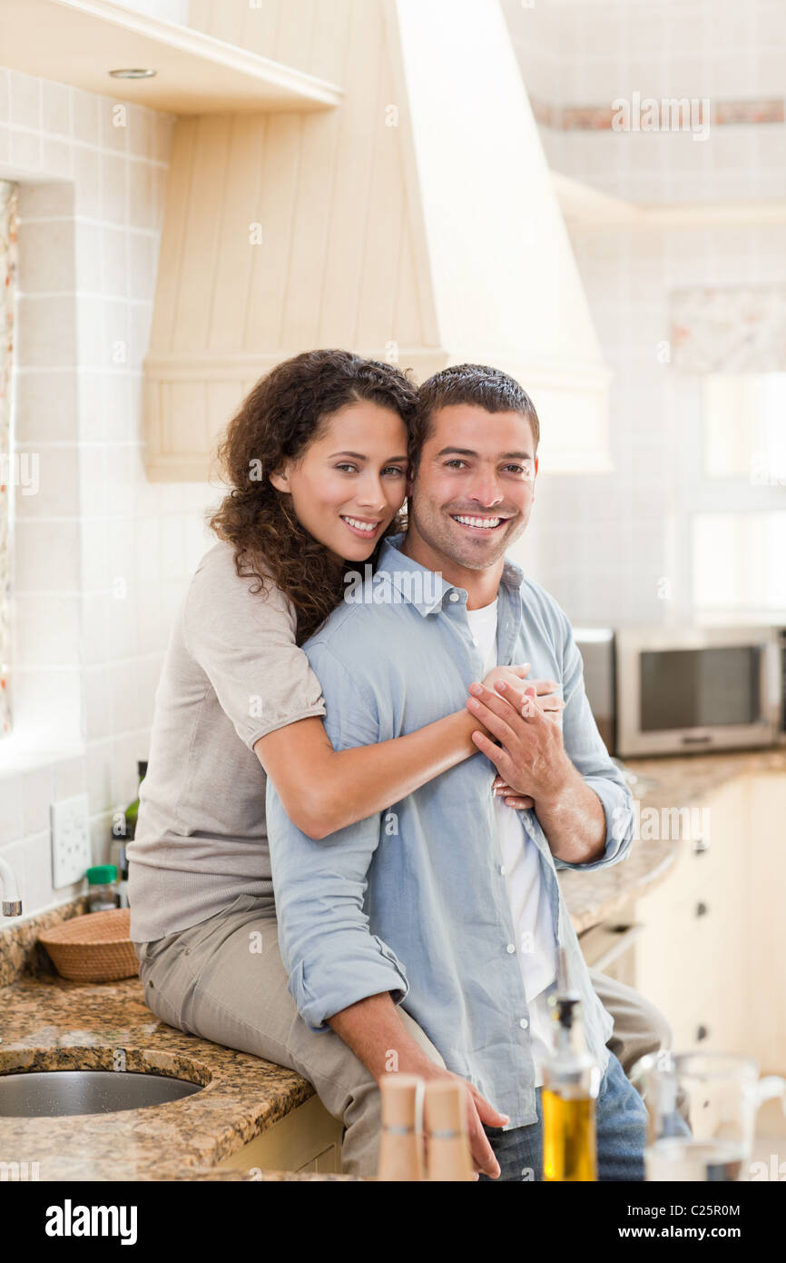 Beautiful couple hugging in the kitchen Stock Photo - Alamy