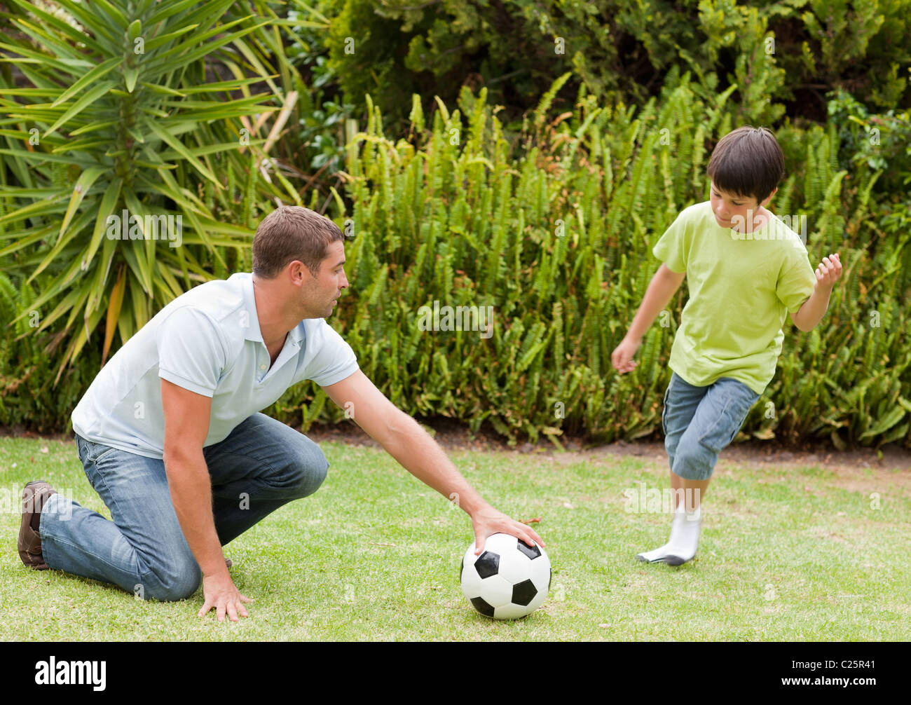 Son playing football with his father Stock Photo - Alamy