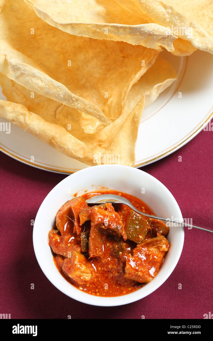 A bowl of spicy green mango pickle, or mango chutney, with crispy ...