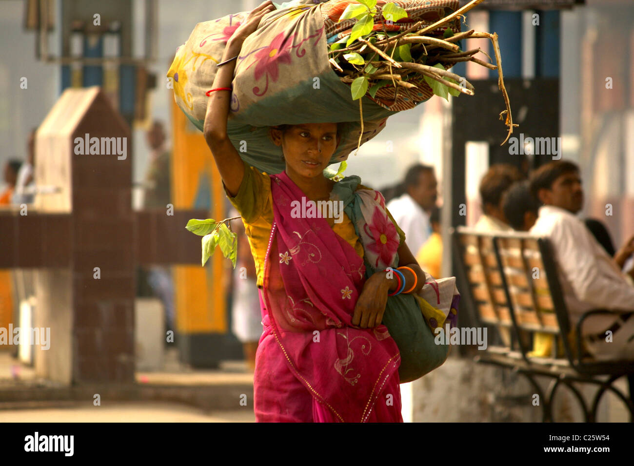 Poor lady returning home with burning woods through railway station ...