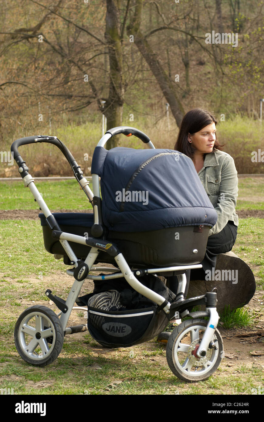 A mother with pushing pram and baby, summer park Stock Photo - Alamy