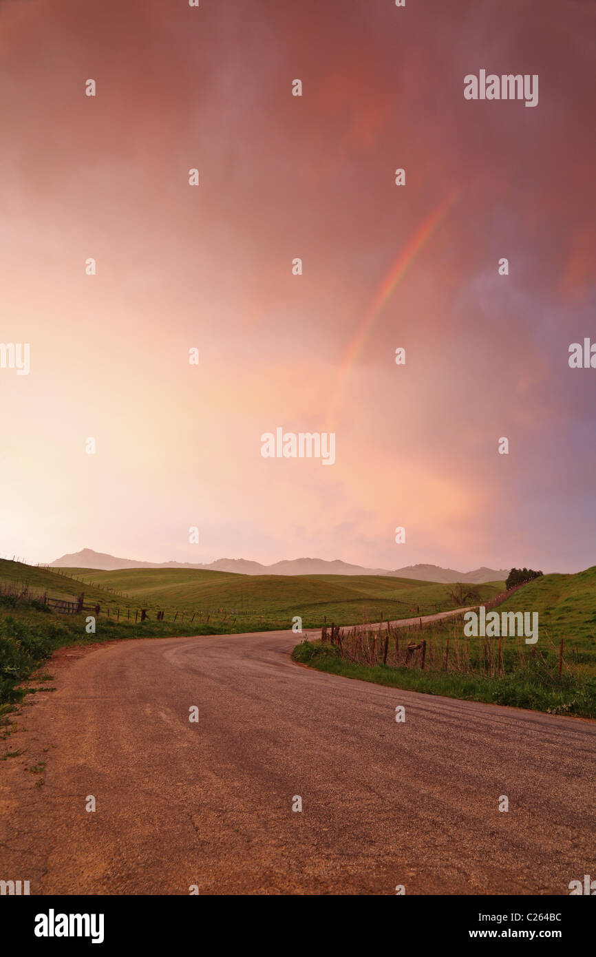 Country road and rainbow Stock Photo - Alamy