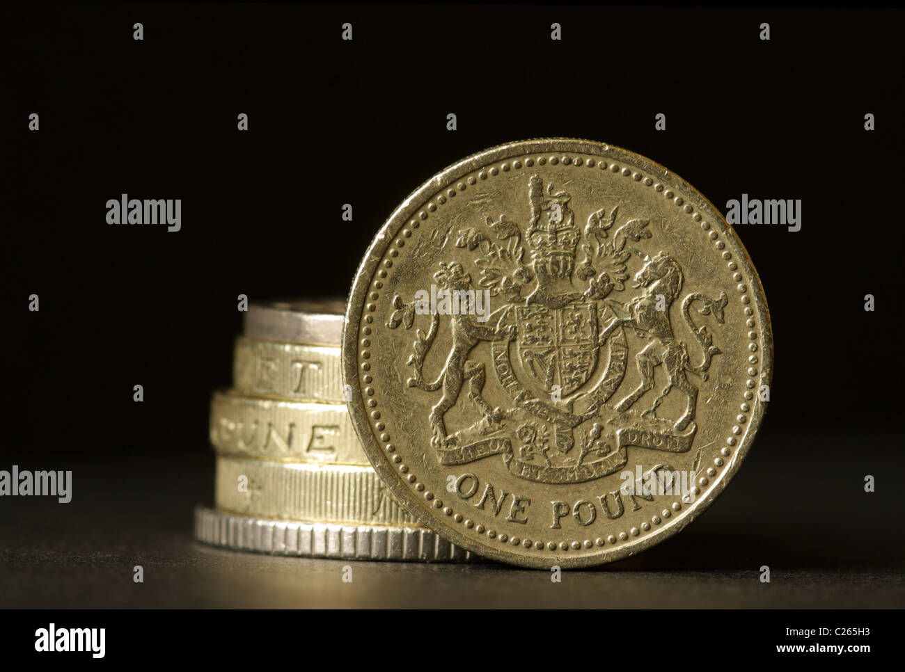 A stack of British coins with a pound coin standing on it`s edge Stock ...