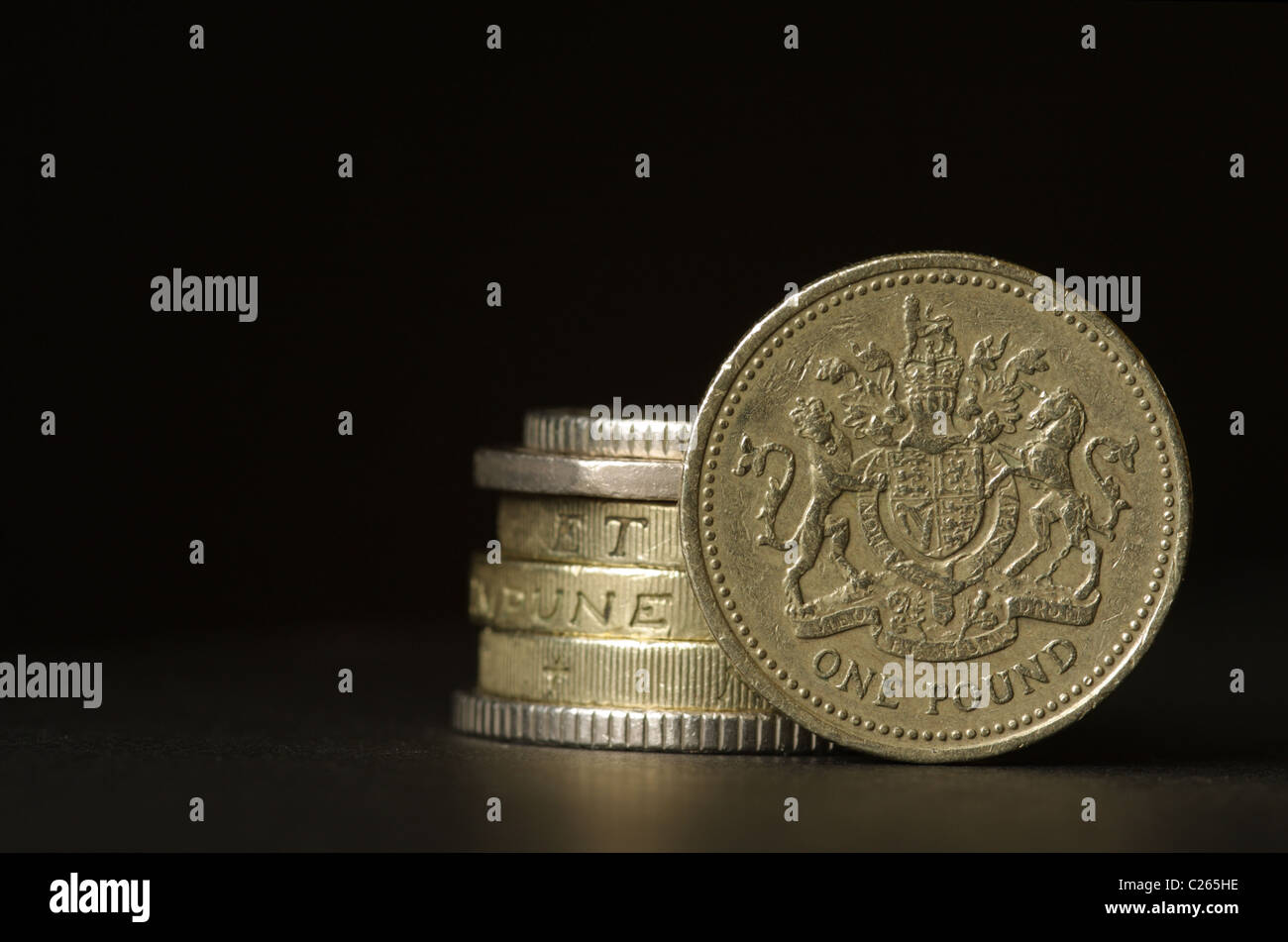 A stack of British coins with a pound coin standing on it`s edge Stock ...
