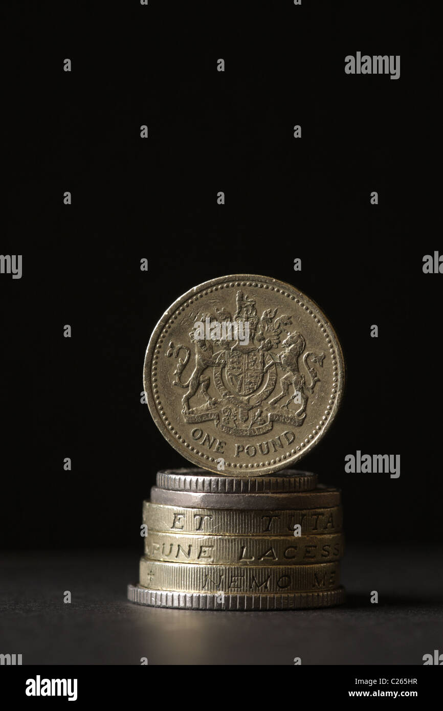 A stack of British coins with a pound coin standing on it`s edge Stock ...