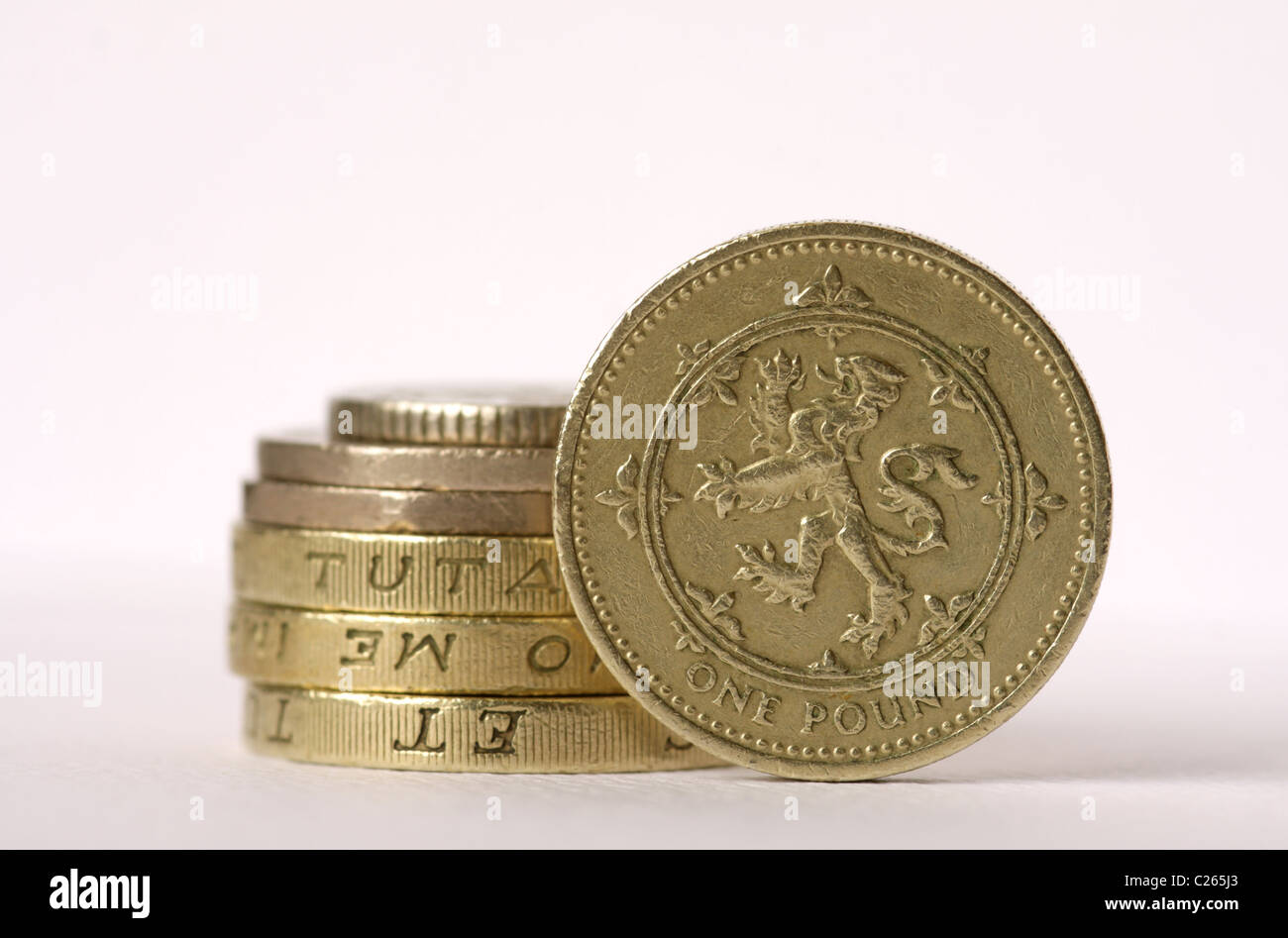 A stack of British coins with a pound coin standing on it`s edge Stock ...