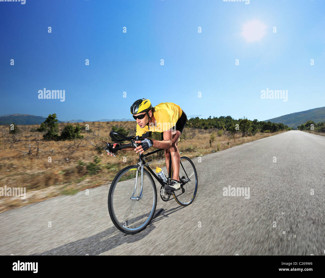 Cyclist riding a bike on an open road in Macedonia Stock Photo - Alamy