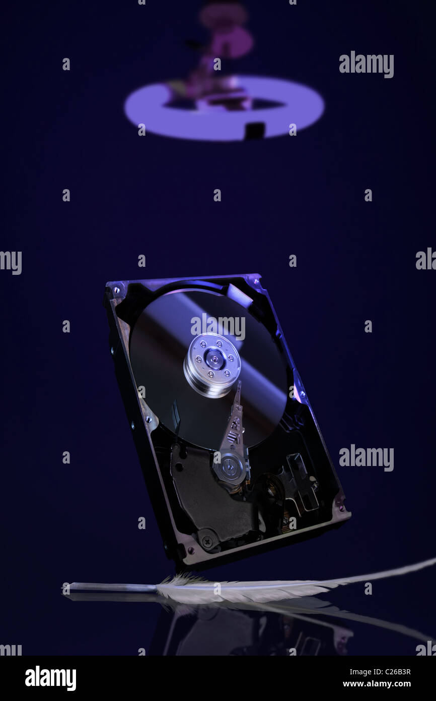 computer hard disk with ancient feather pen on reflective surface, all ...