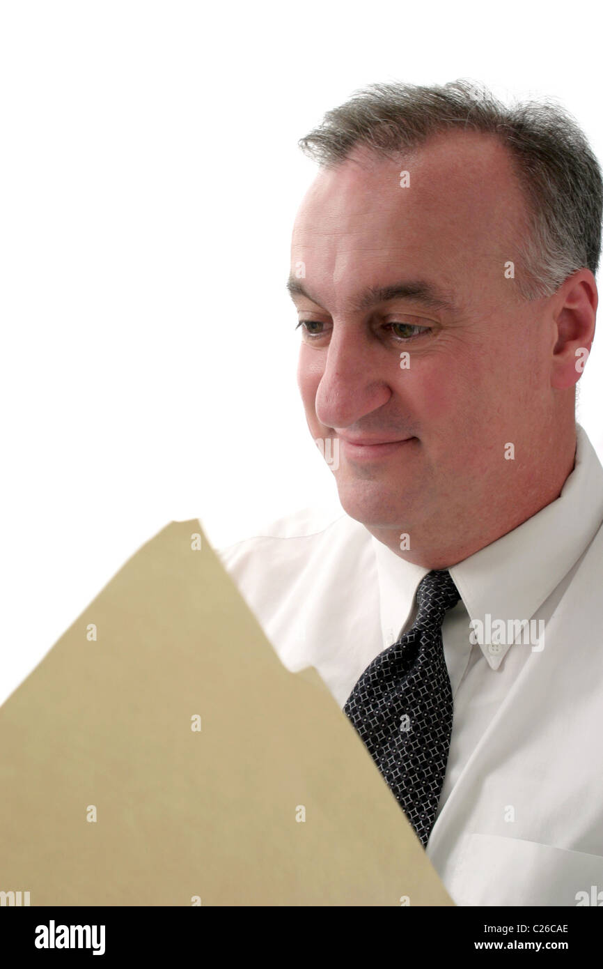 smiling business man reading report in manila folder; isolated on white ...