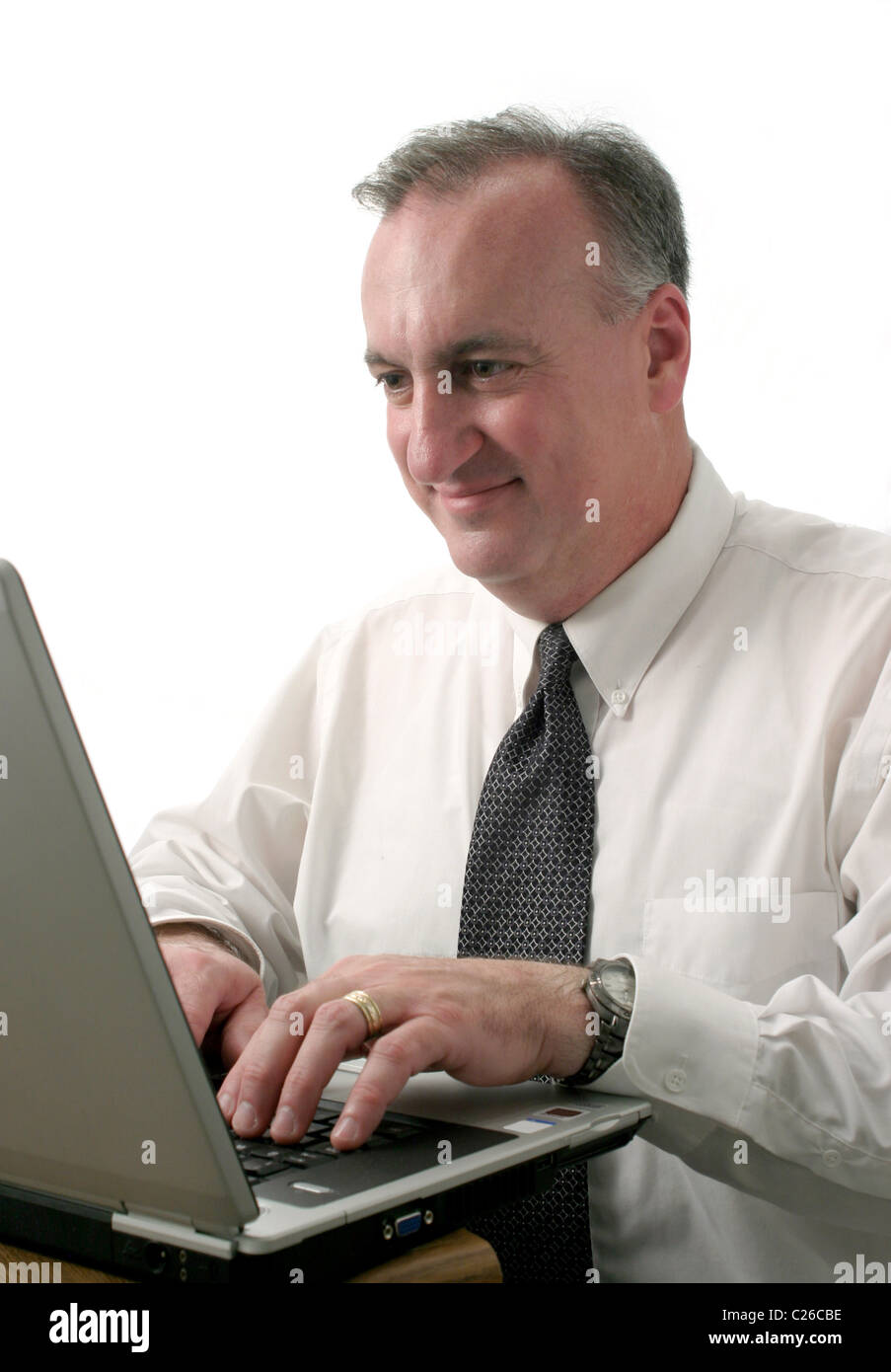smiling business man typing and working on laptop computer; isolated on ...