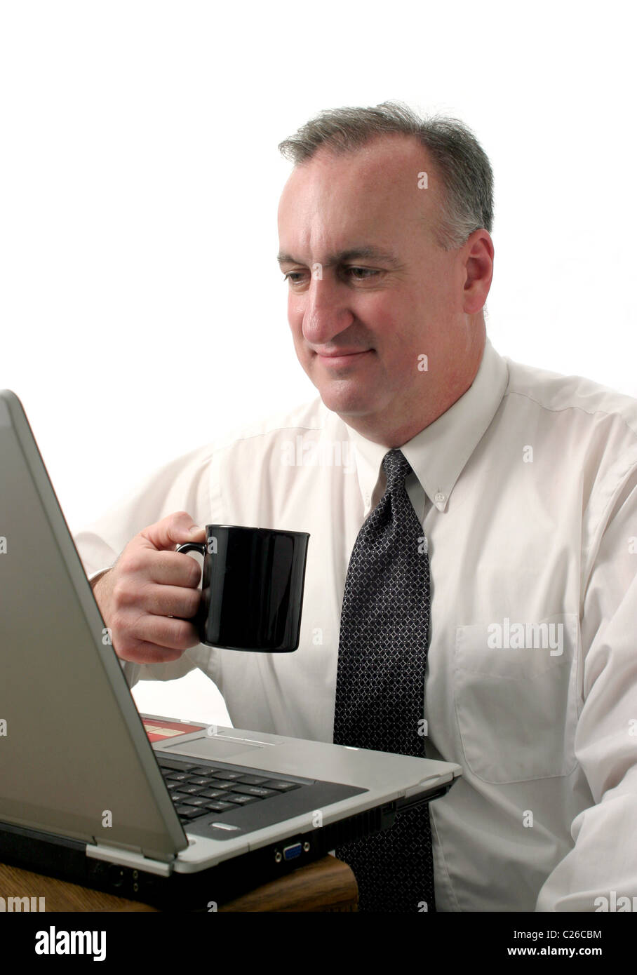 smiling business man drinking coffee and looking at laptop computer ...