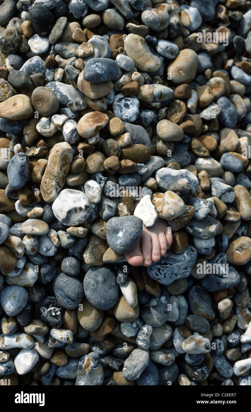 close up of feet buried in pebbles and only toes are exposed Stock ...