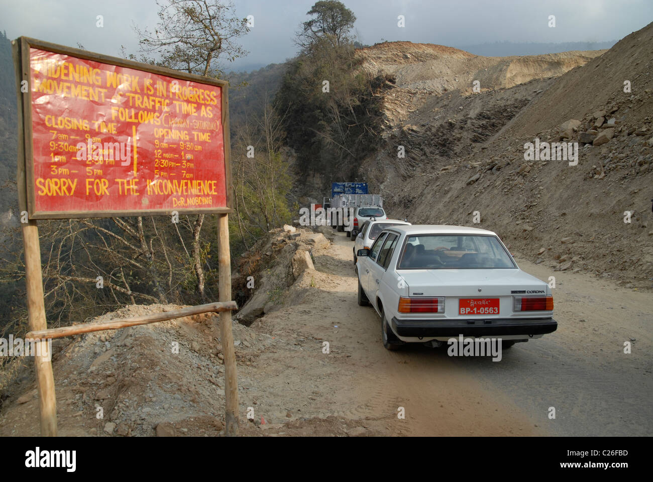 Road closure with sign for the opening times and cars waiting Stock ...