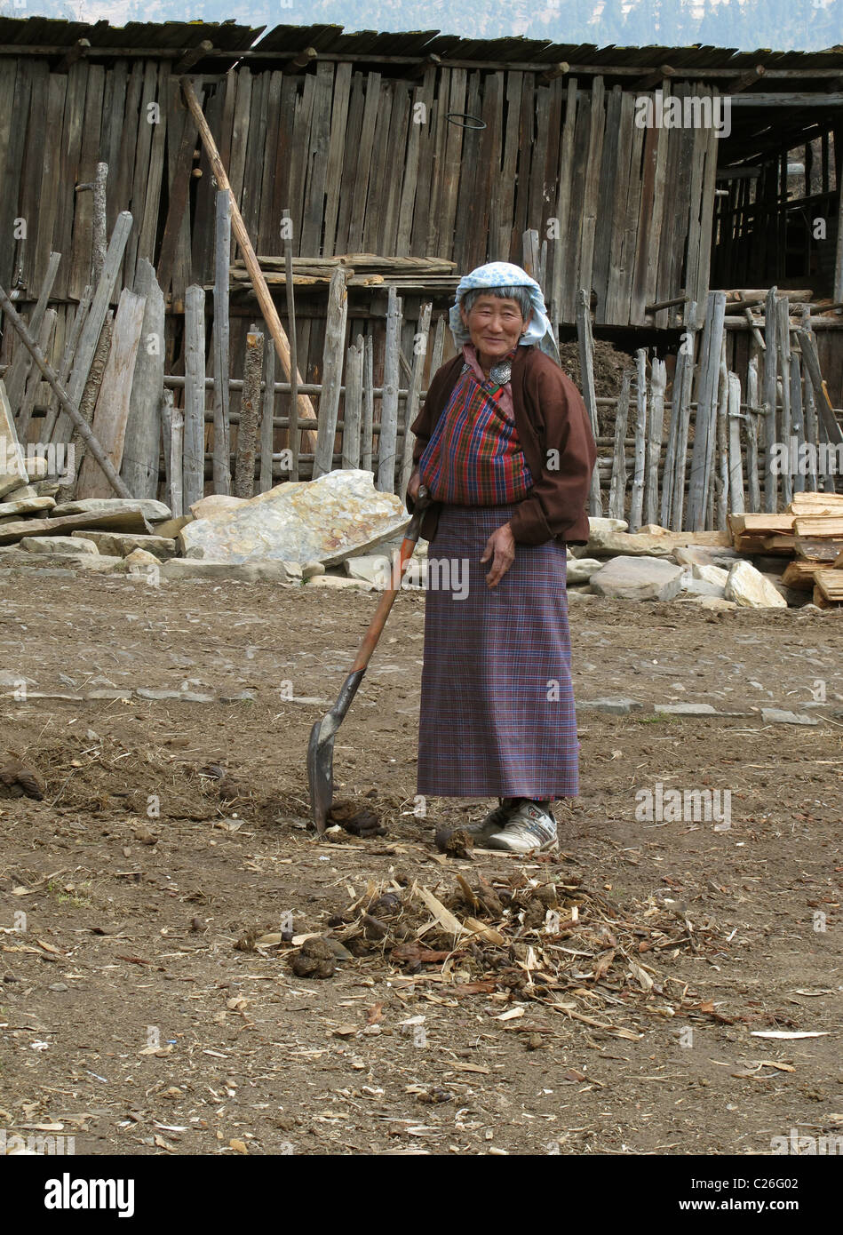 A woman cleaning the village square, Ura, Central Bhutan Stock Photo ...