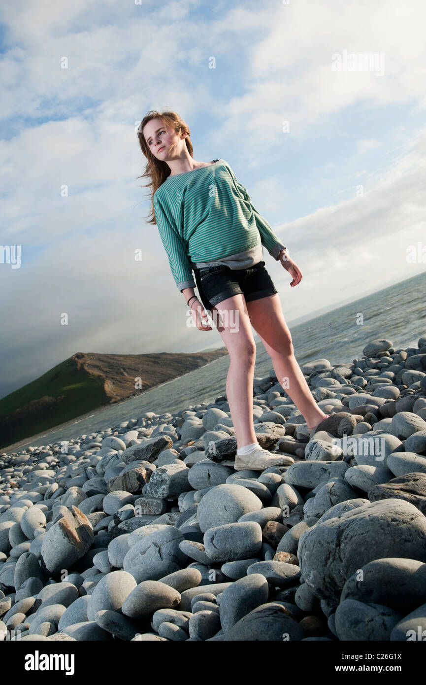 A 12 year old girl standing on a rocky beach, wales UK Stock Photo - Alamy