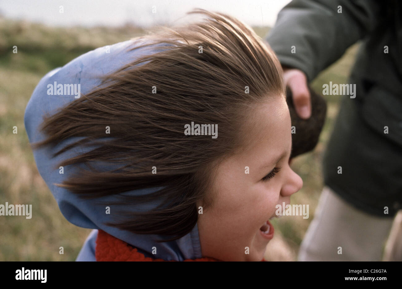 young girl laughing with a strong wind blowing her hair back Stock ...