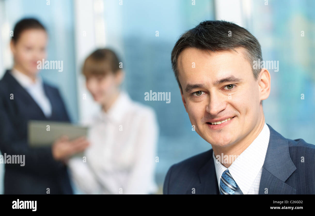 Portrait of a mature smiling manager against his colleagues Stock Photo ...