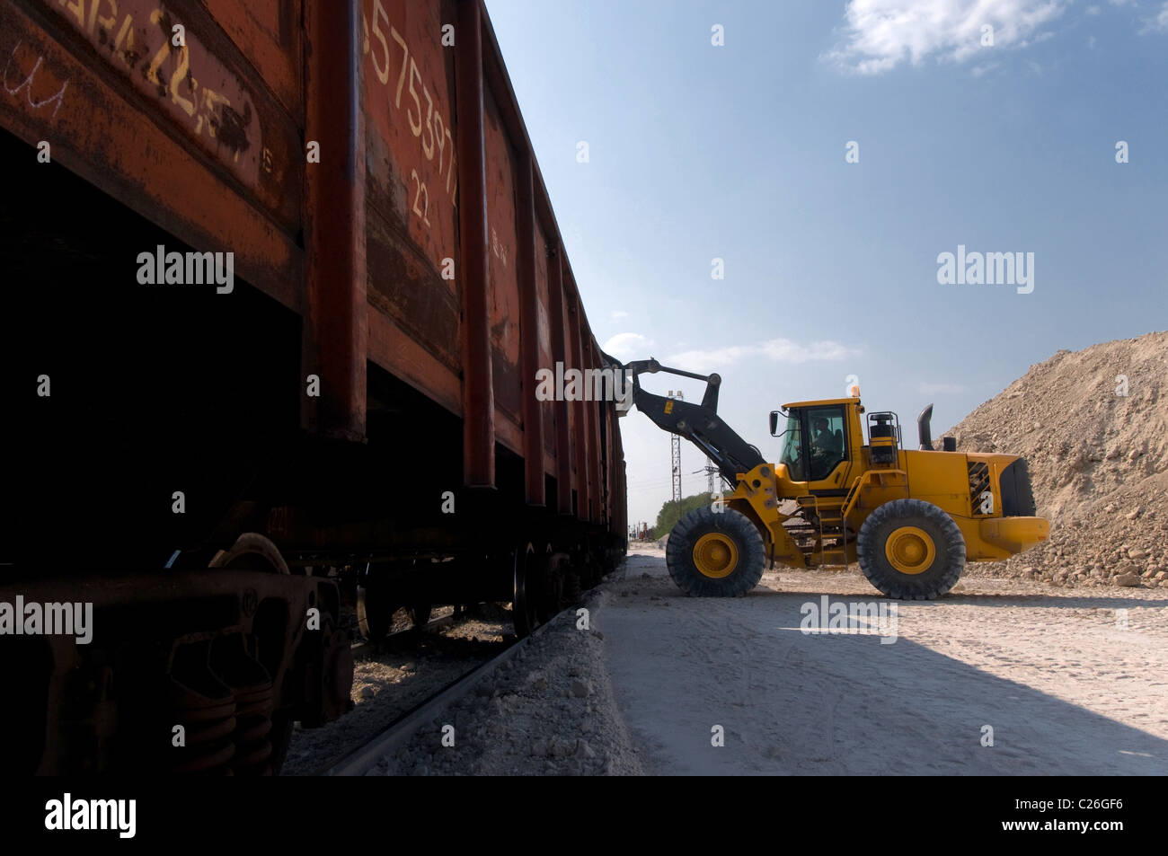 excavator loads gravel into the car of a train Stock Photo - Alamy