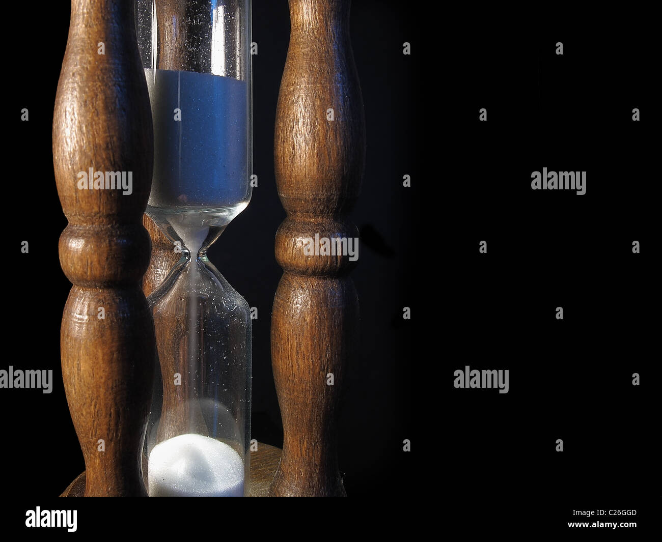 An old sand glass of wood on black background Stock Photo - Alamy