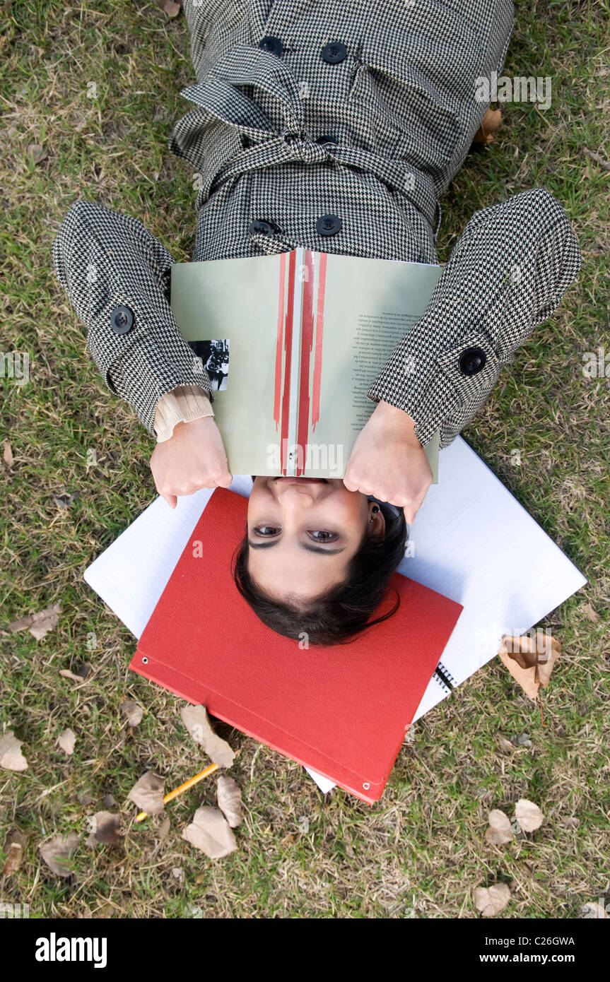 Lady, woman, body, lay, laying, down, hold, holding, a, book, red, on ...