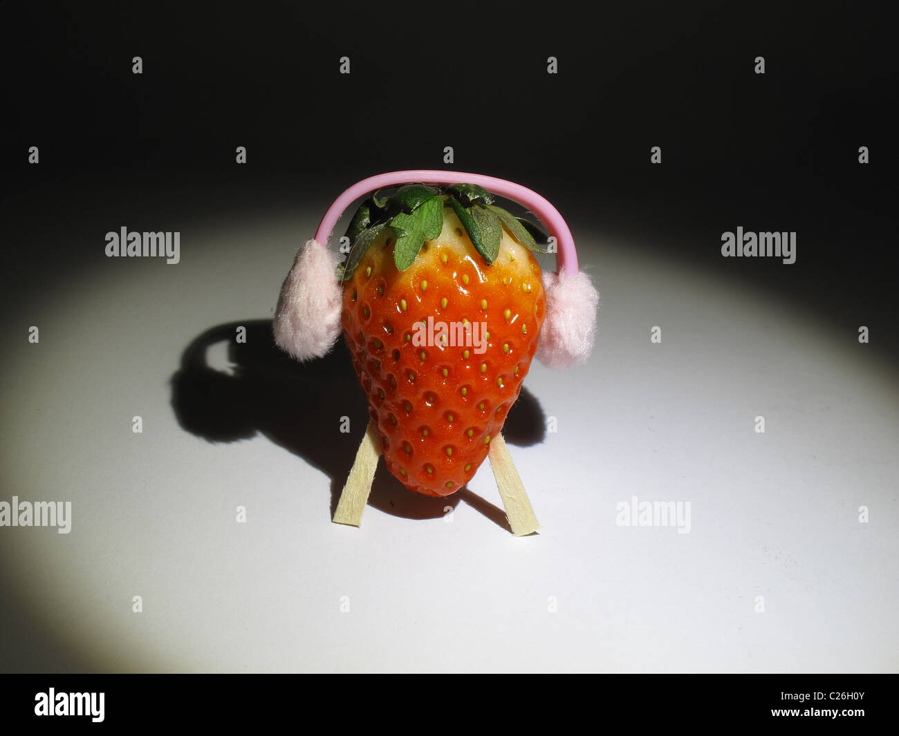 Strawberry wearing ear-muffs and its shadow Stock Photo - Alamy