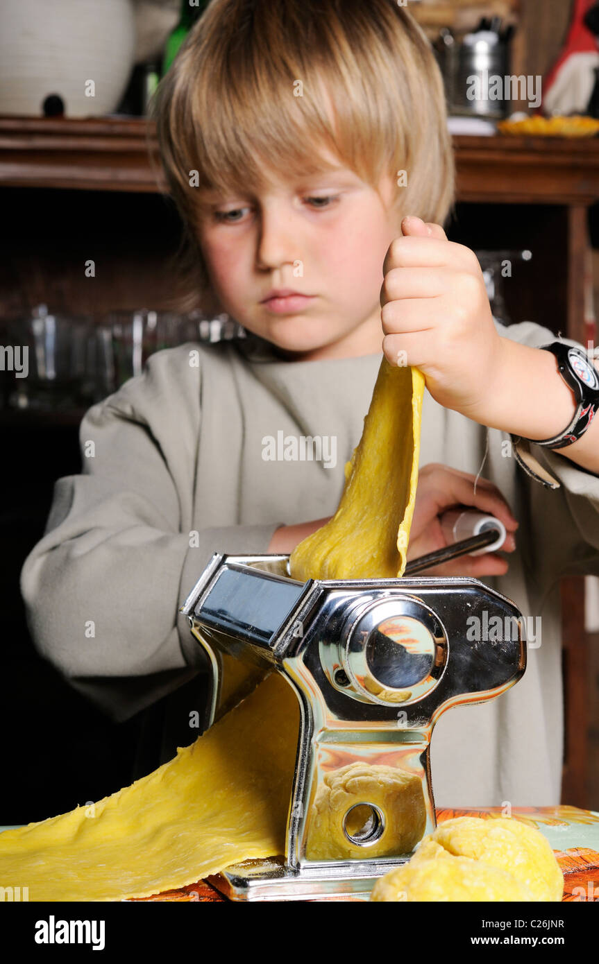 Stock photo of a young boy making fresh pasta with a pasta machine ...