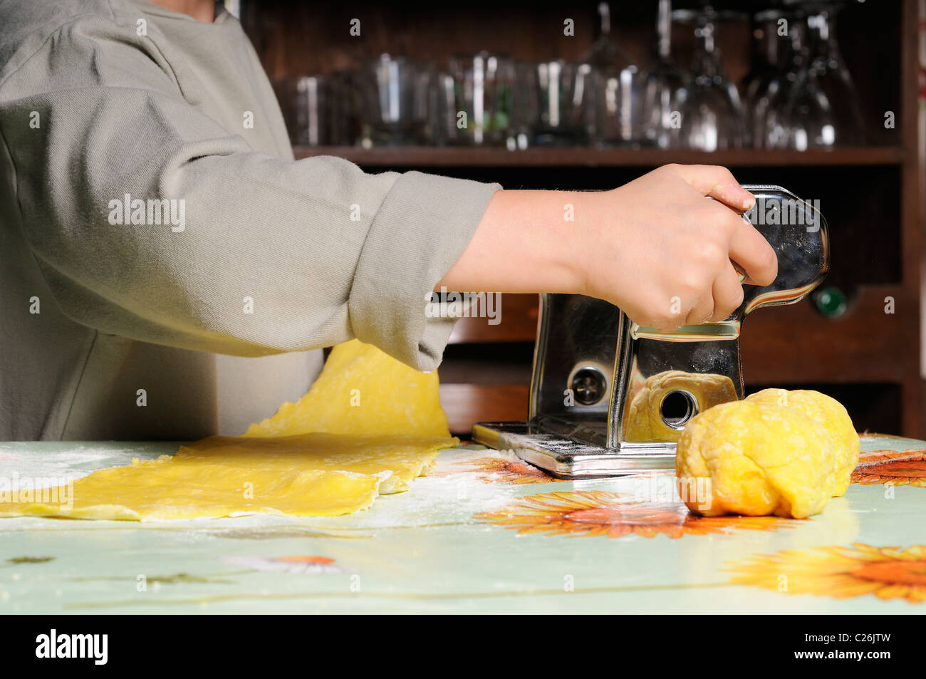 Stock photo of a young boy making fresh pasta with a pasta machine ...
