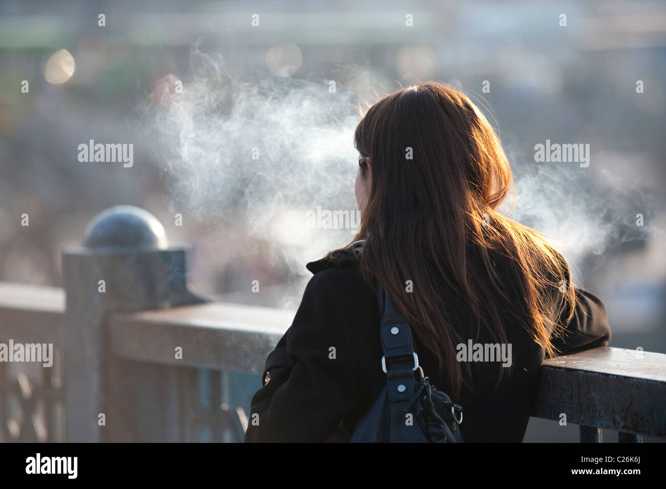 Young girl standing smoking on bridge Stock Photo - Alamy