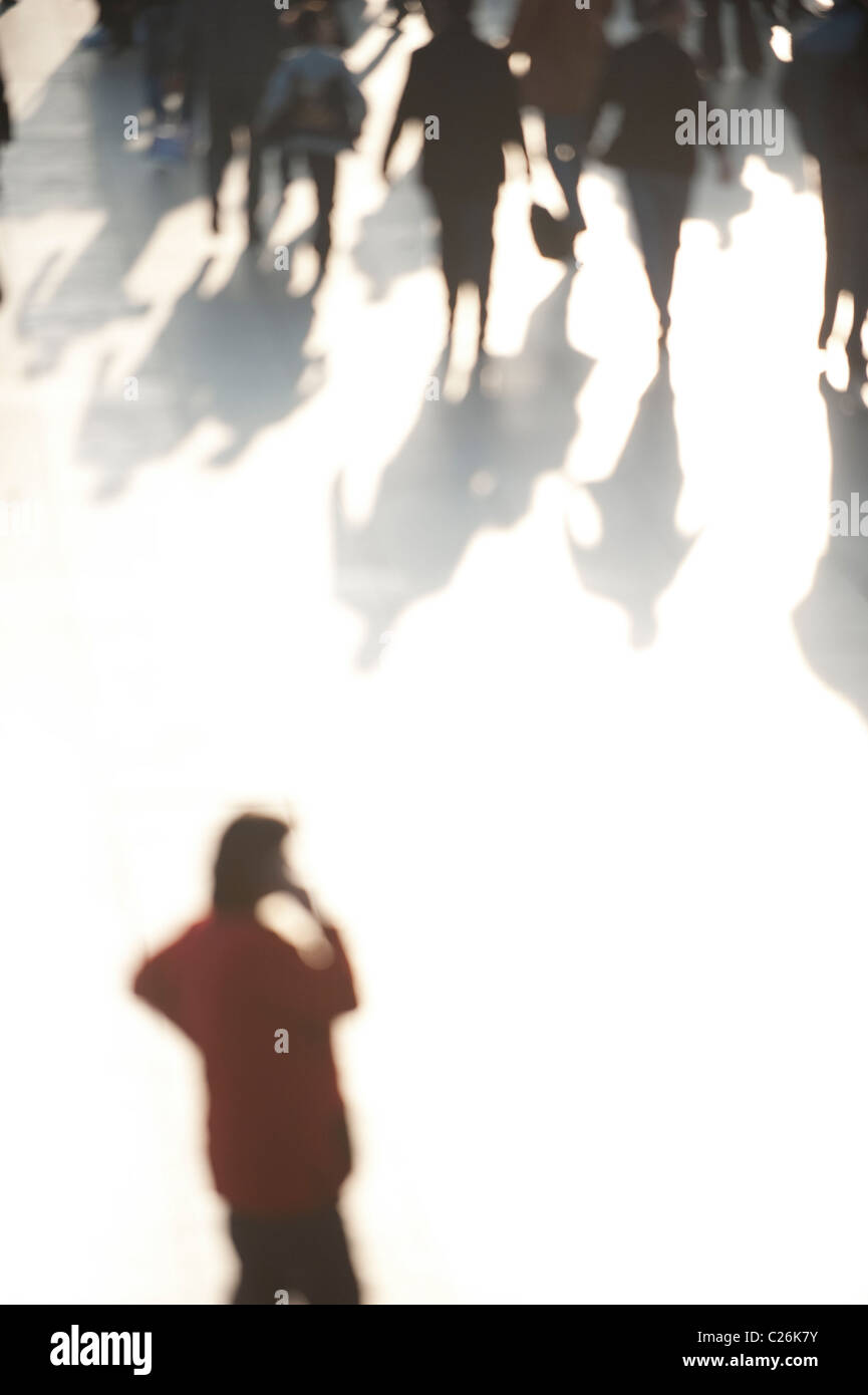 Blur image of crowd in bright sunlight, with person on phone Stock ...