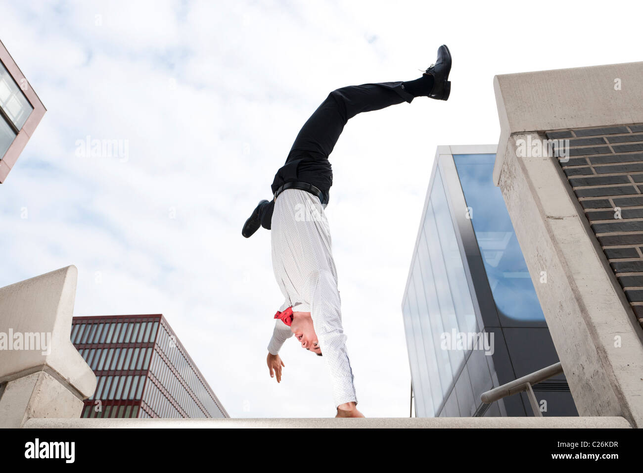 Jumping young buiness man in front of buildings Stock Photo - Alamy