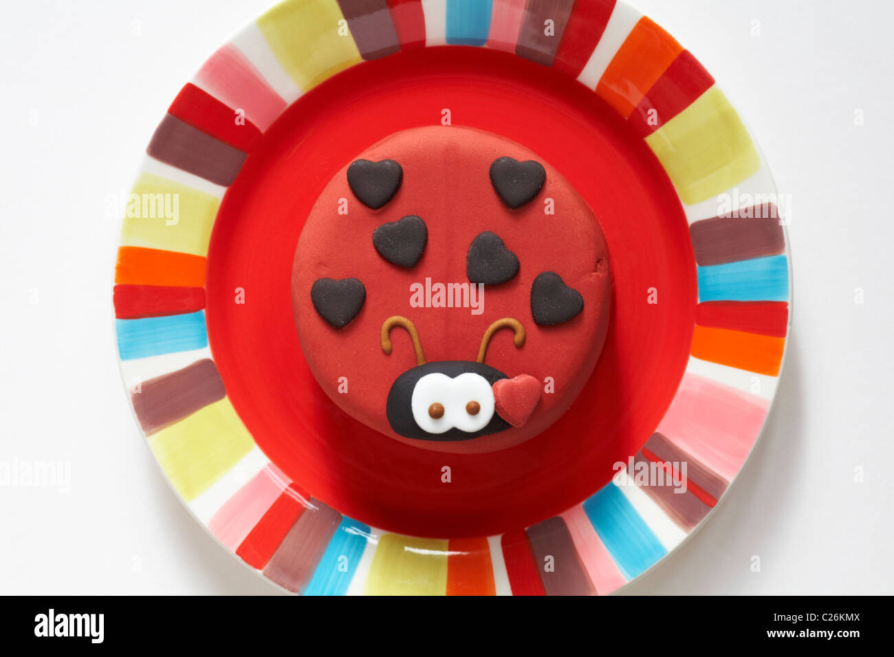 marzipan cake in shape of a ladybird lady bird placed on colourful red ...