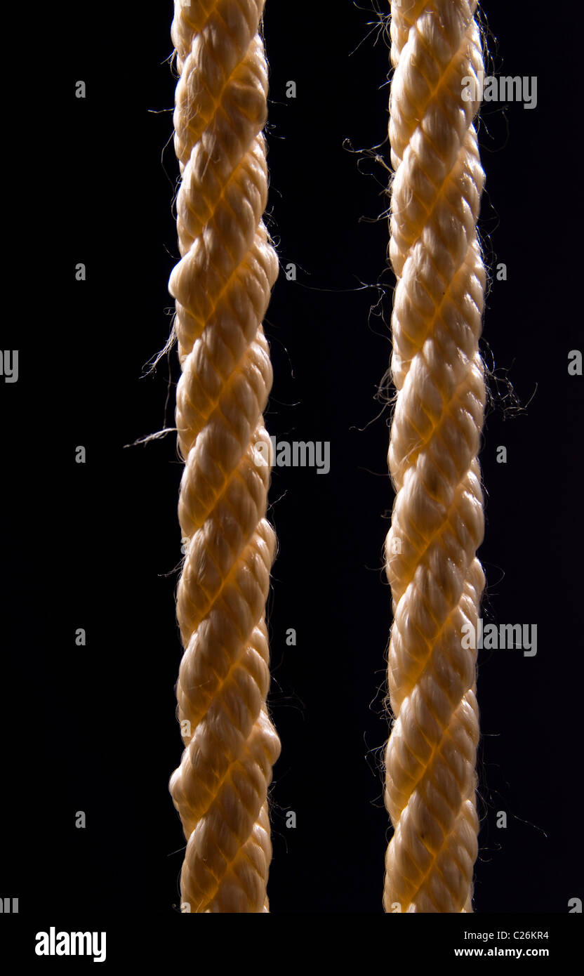 thick rope hanging on a background of black walls Stock Photo - Alamy