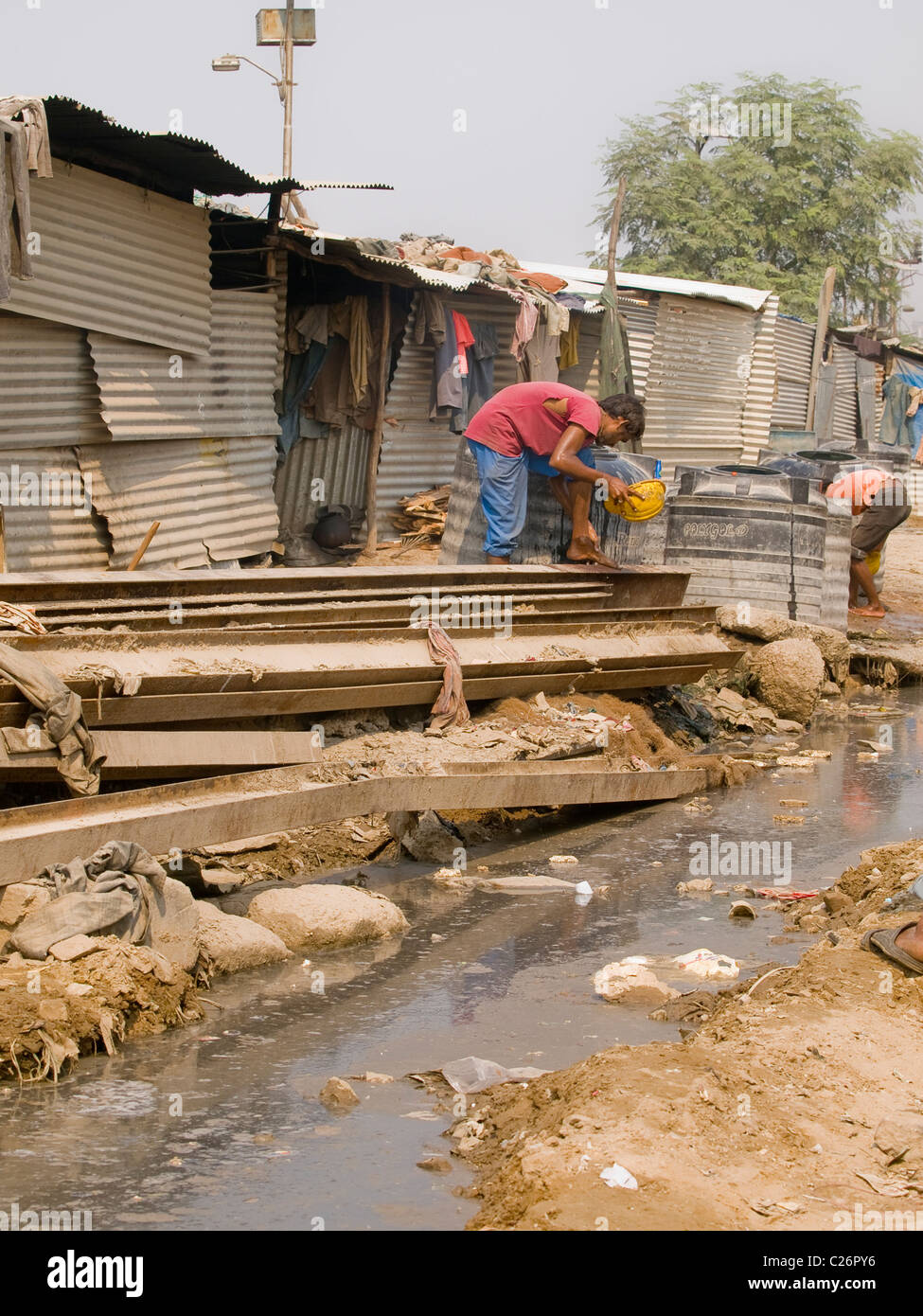 Poor man in the slums in India trying to get clean drinking water Stock ...