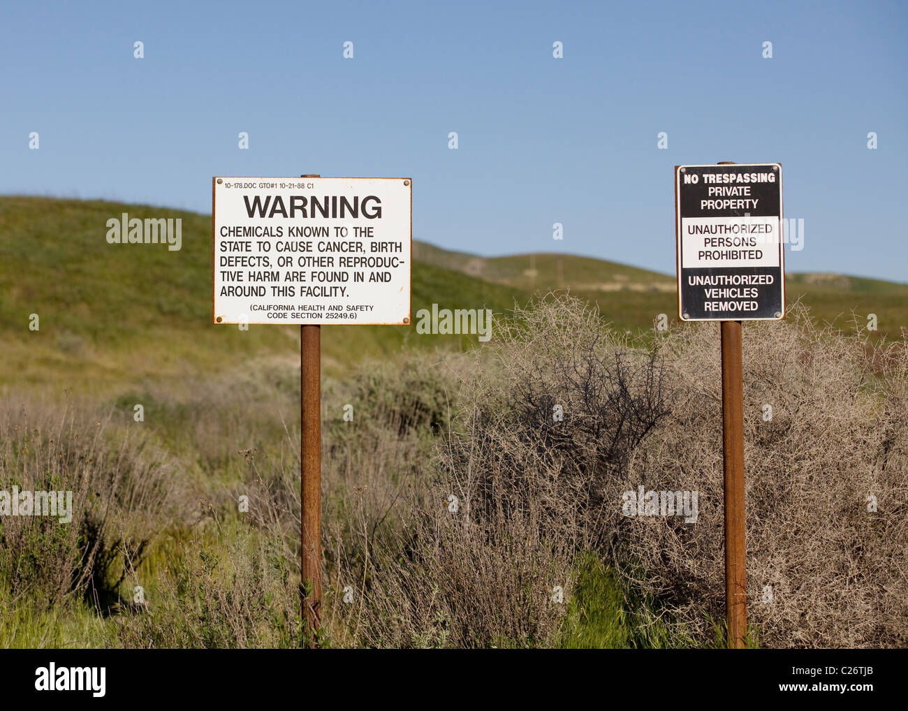 Posted harmful chemical warning signs in grassy field Stock Photo - Alamy