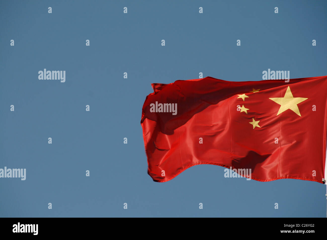 one chinese flag flying in wind and blue sky Stock Photo - Alamy