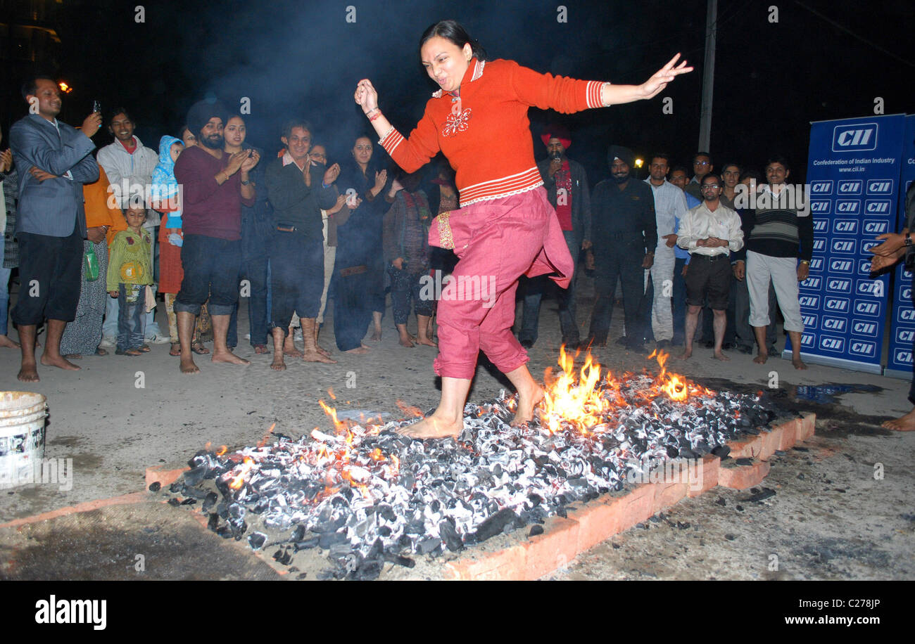 A corporate employee walks over burning embers during a motivational ...