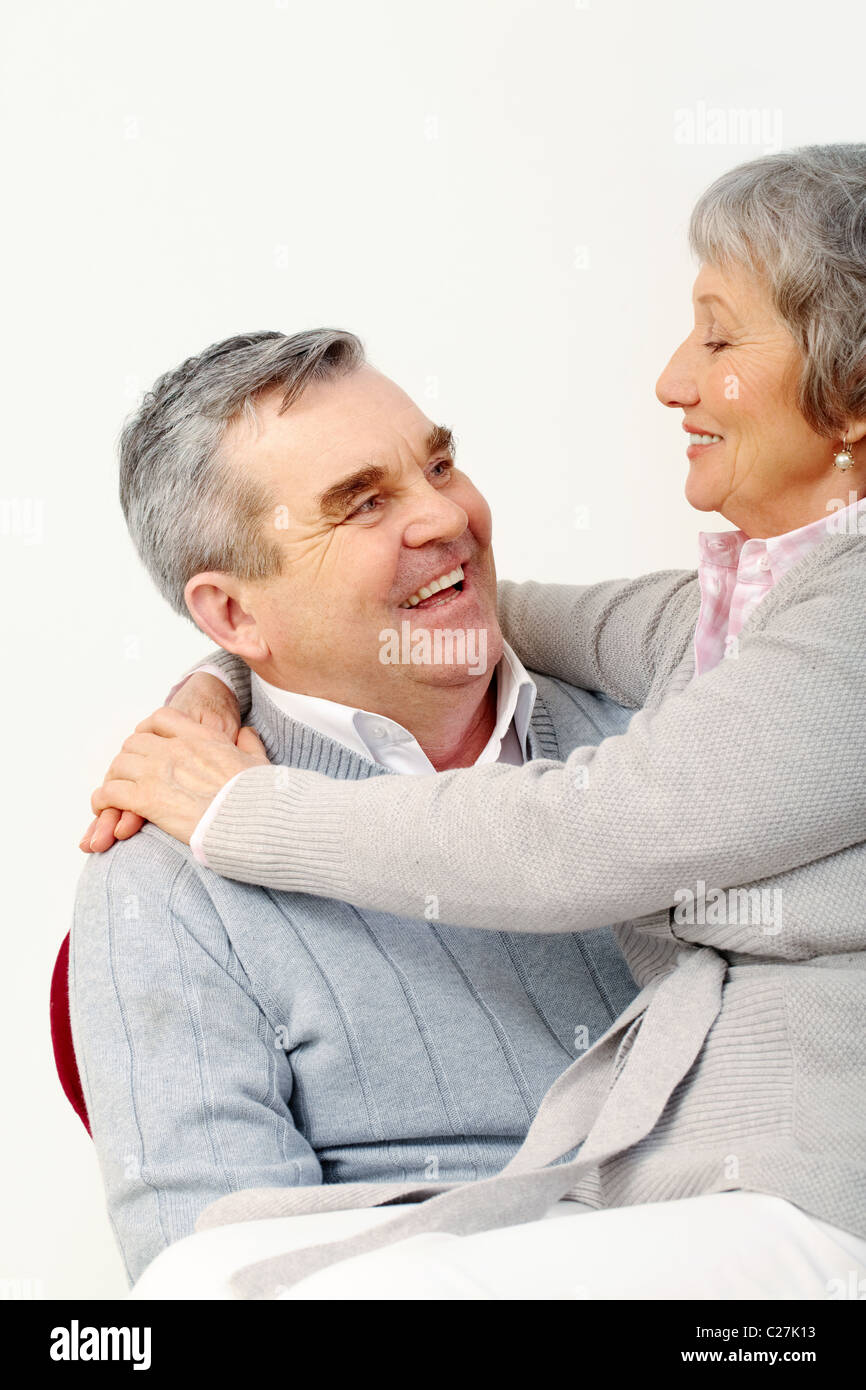 Photo of senior woman sitting on man’s knee and embracing him Stock ...