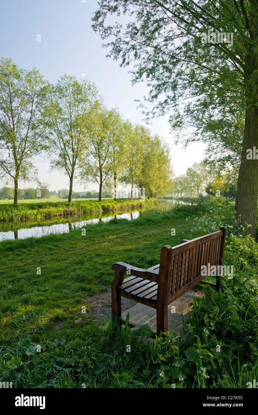 Rural setting with a wooden seat over looking a small river Stock Photo ...