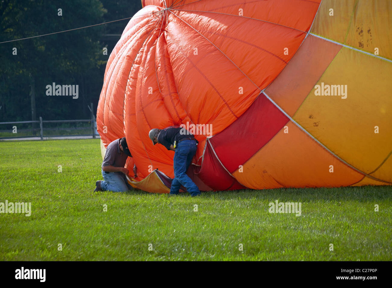 Two men work the rigging of an inflating hot air balloon Stock Photo ...