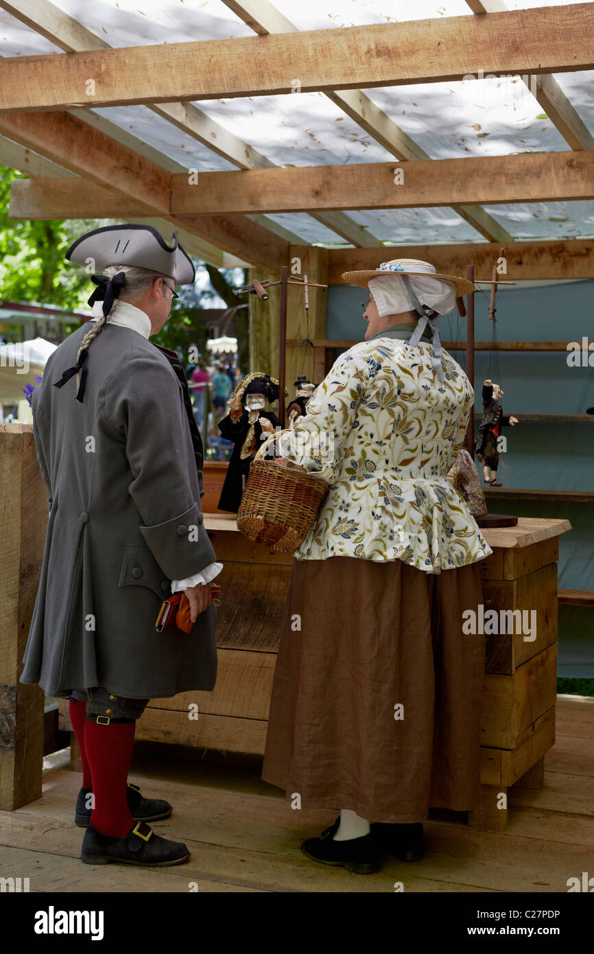 Costumed interpreter market fair patrons admiring marionettes for sale ...