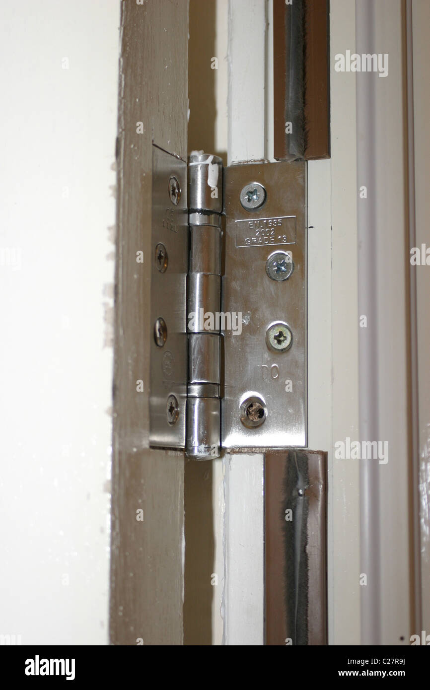 fitting a hinge onto a door frame Stock Photo - Alamy